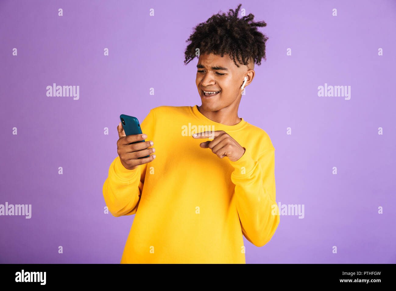 Portrait of joyful african american man wearing bluetooth earpod ...