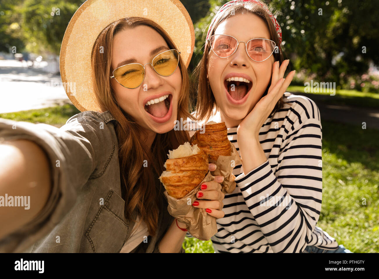 Two laughing young girls friends having fun at the park, taking a ...