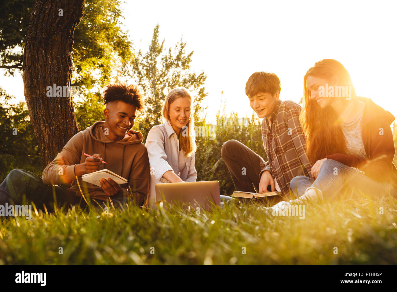 Group of positive multhiethnic students doing homework together at the ...