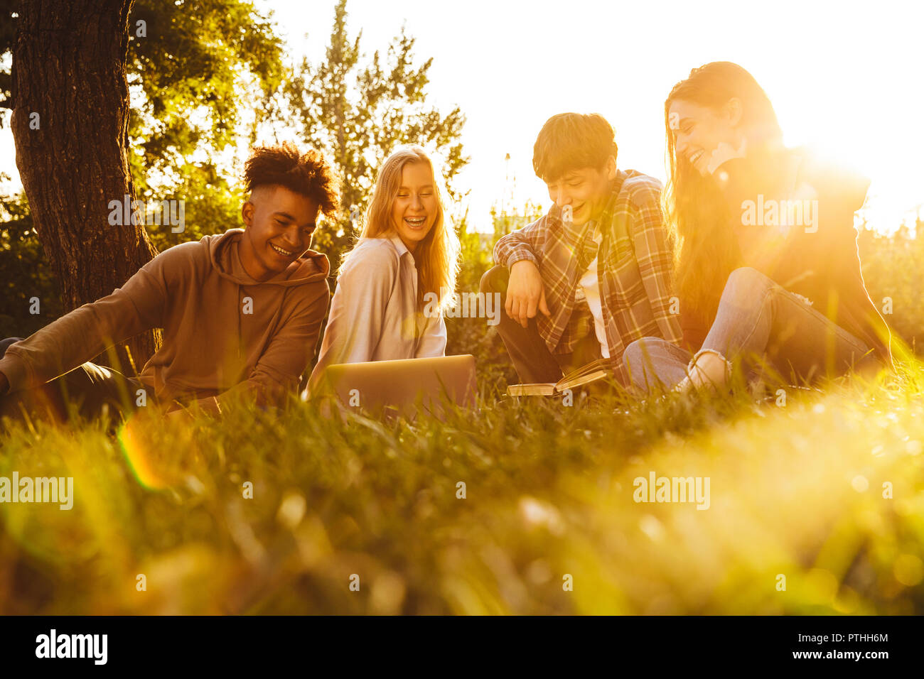 Group of laughing multhiethnic students doing homework together at the ...