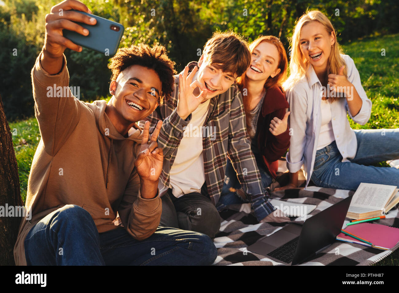 Group of positive multhiethnic students doing homework together at the ...
