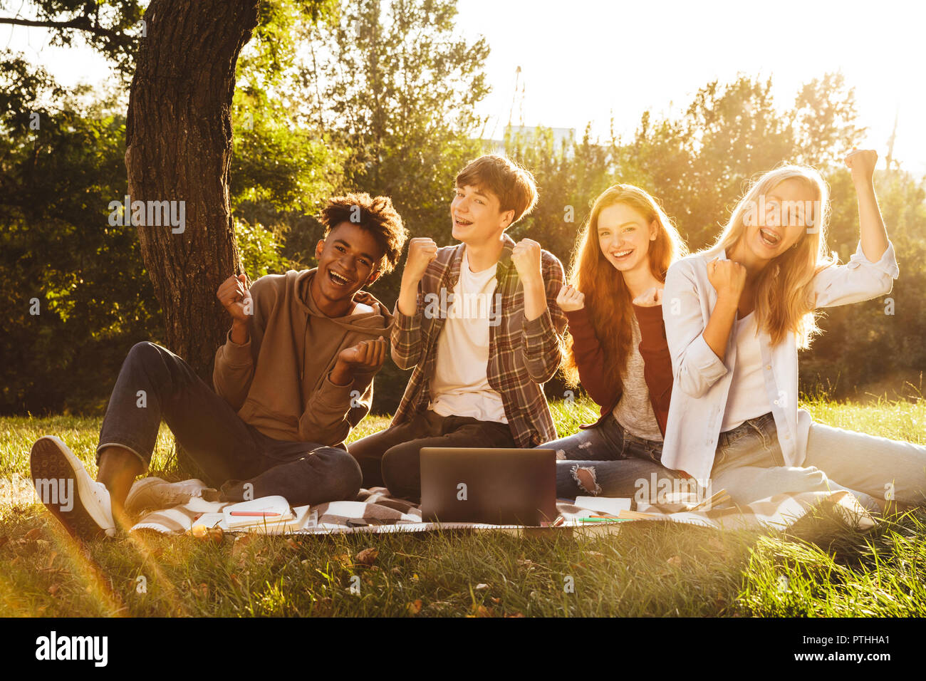 Group of cheerful multhiethnic students doing homework together at the ...