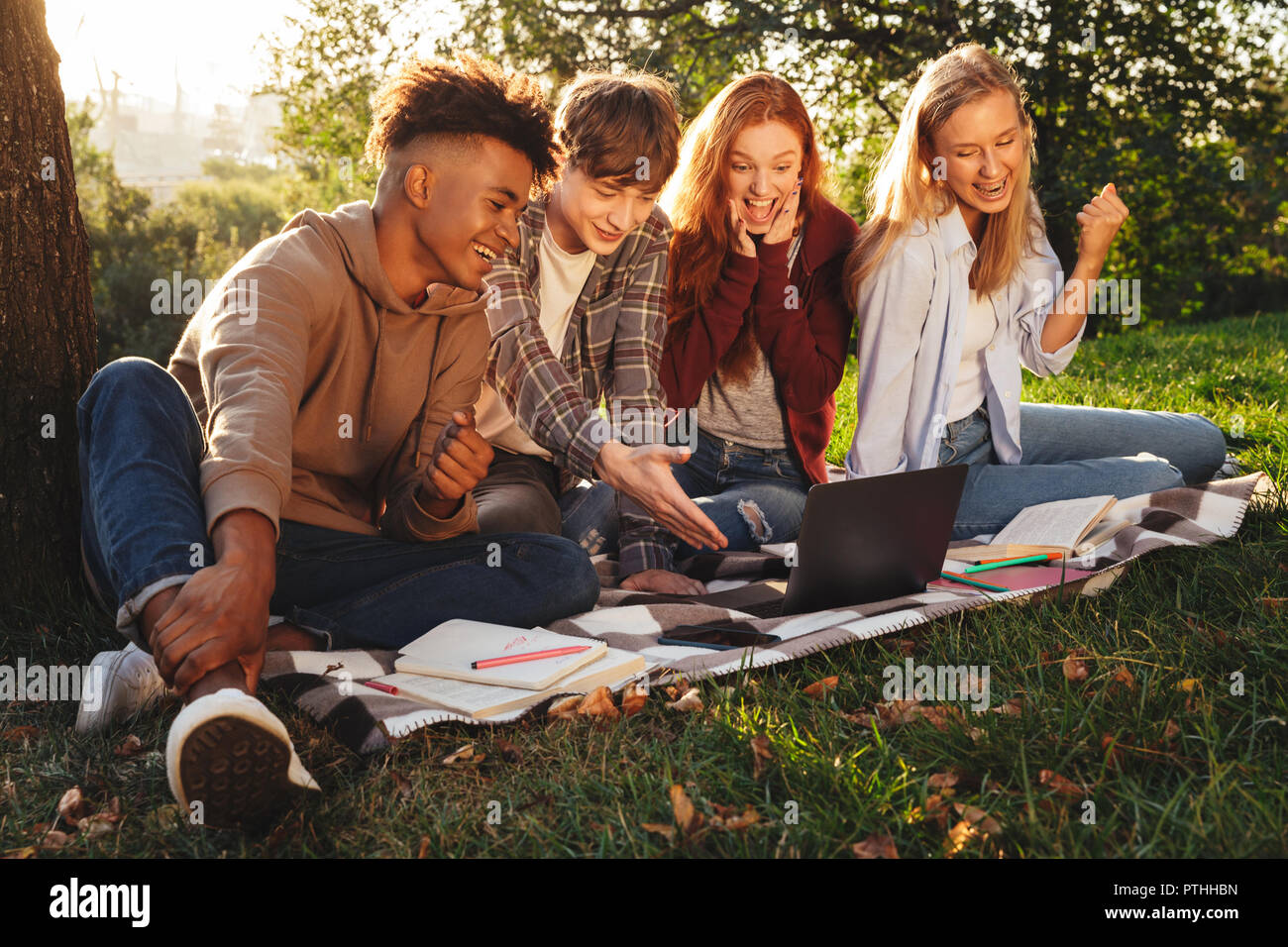Group of happy multhiethnic students doing homework together at the ...