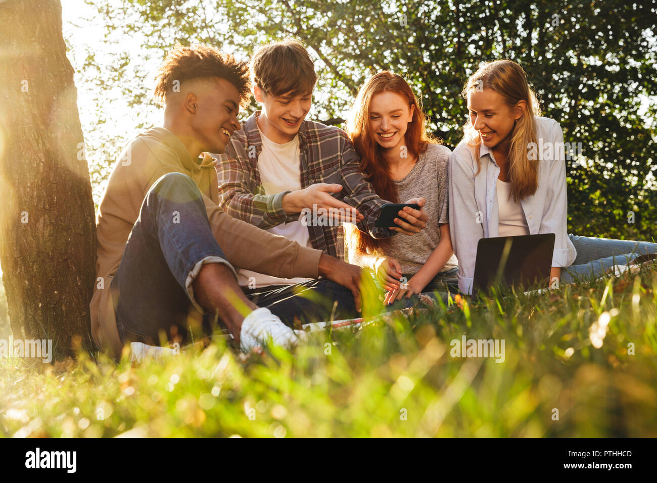 Group of happy multhiethnic students doing homework together at the ...