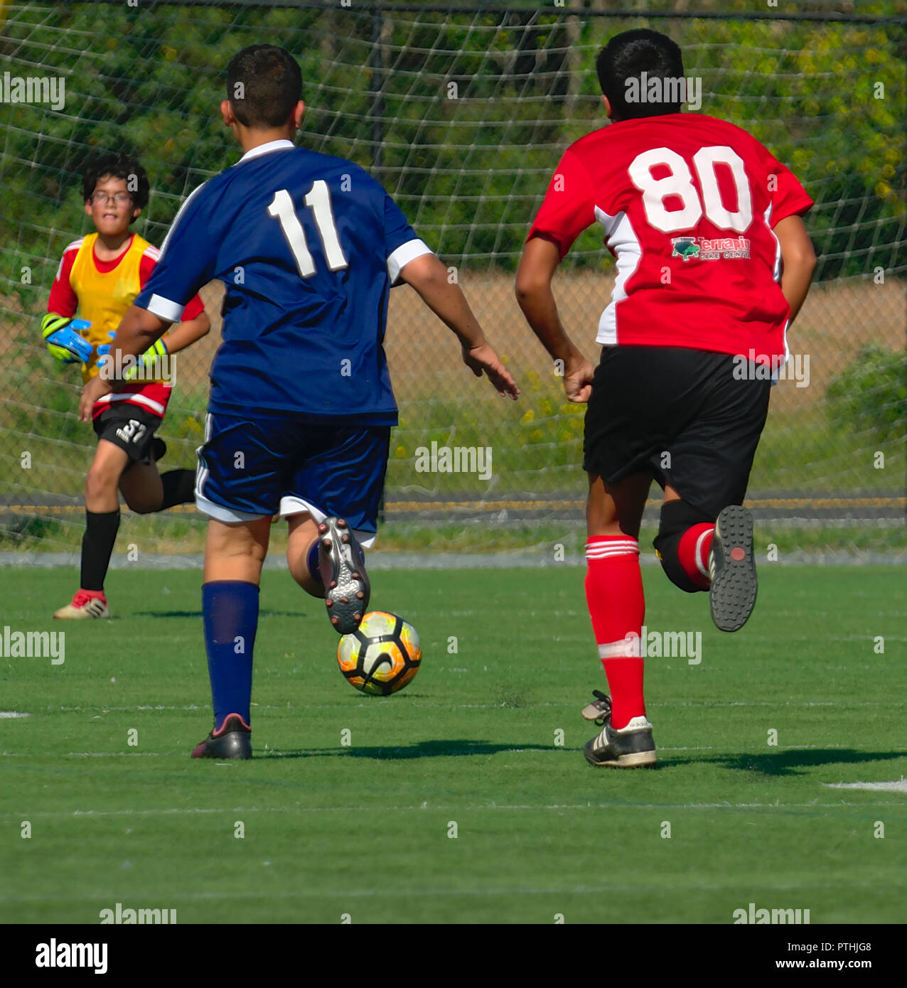Youths playing organized soccer on field Stock Photo - Alamy