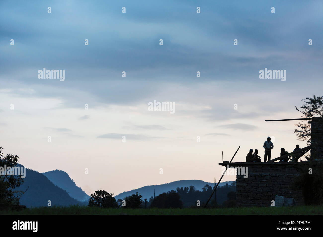 Friends hanging out on cabin rooftop, Supi Bageshwar, Uttarakhand ...
