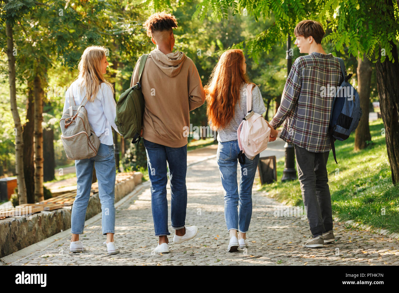 Back view group of students with backpacks walking at the campus ...