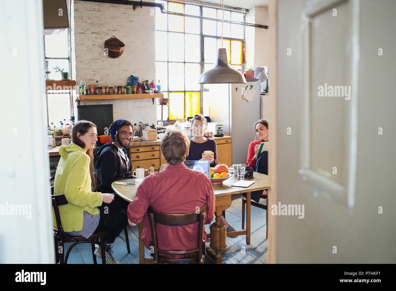 Young roommate friends at breakfast table in apartment kitchen Stock ...