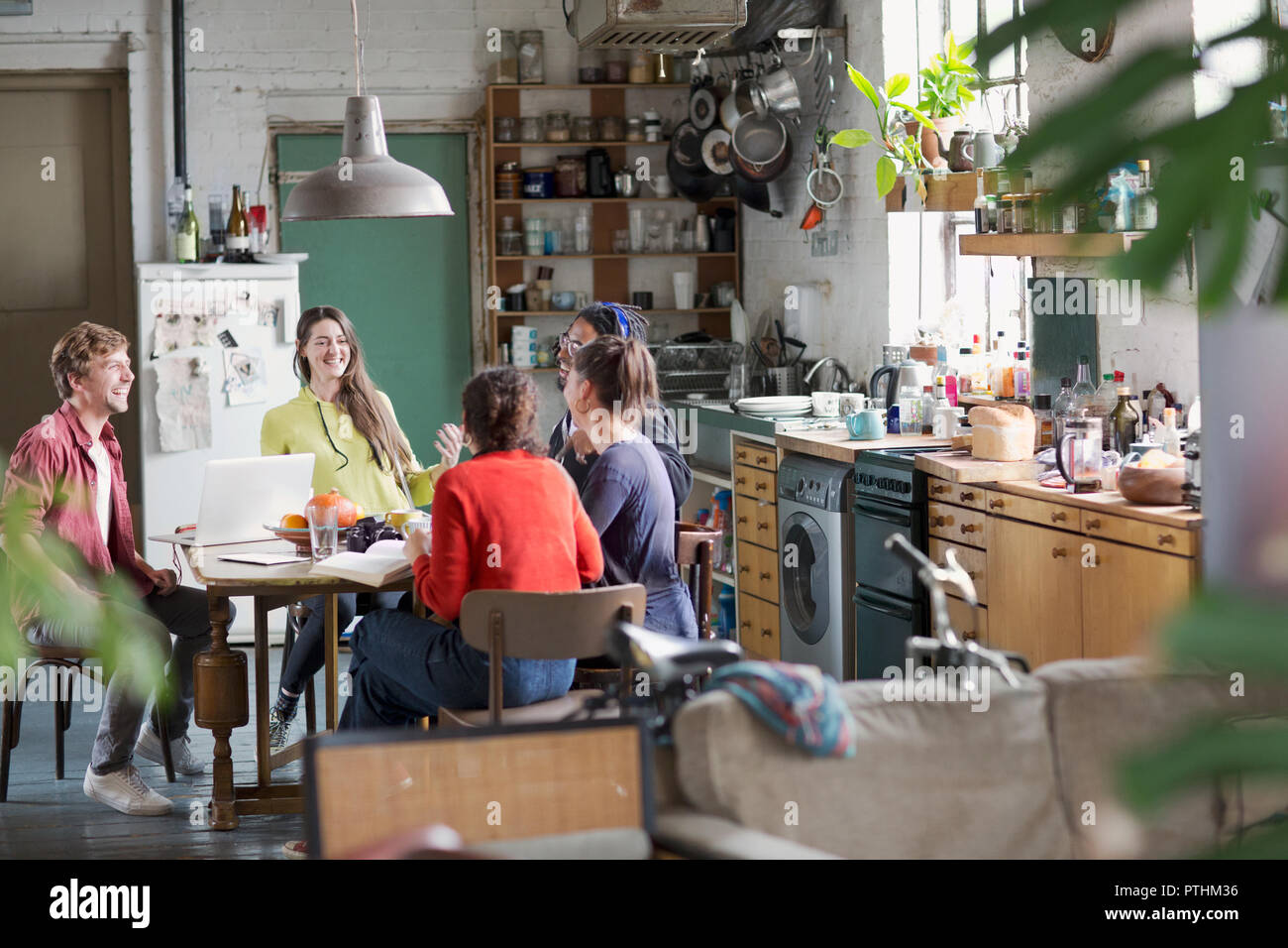 Young college student roommate friends studying at kitchen table in ...