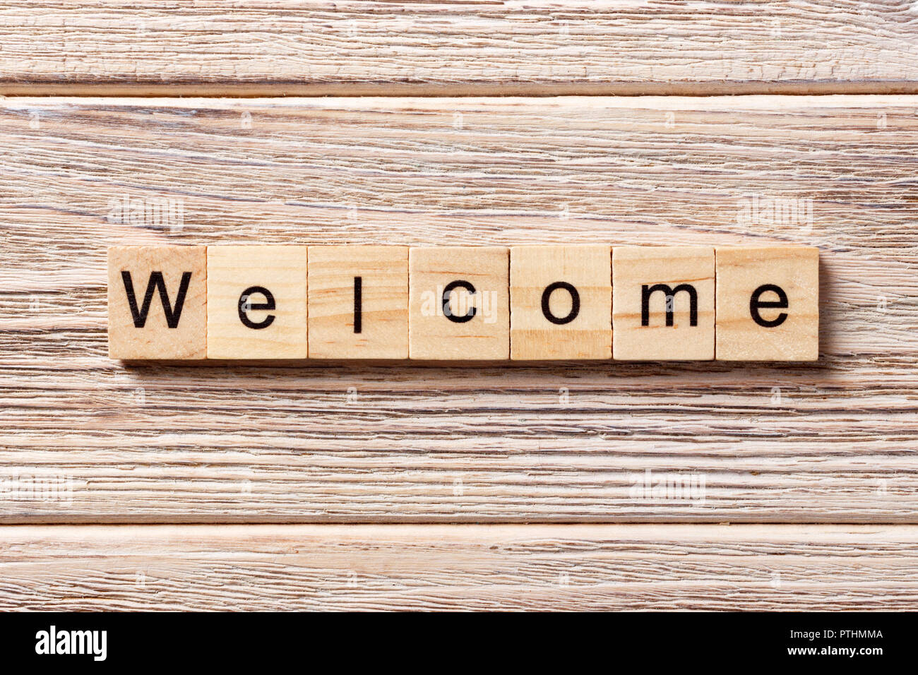 WELCOME word written on wood block. WELCOME text on table, concept ...