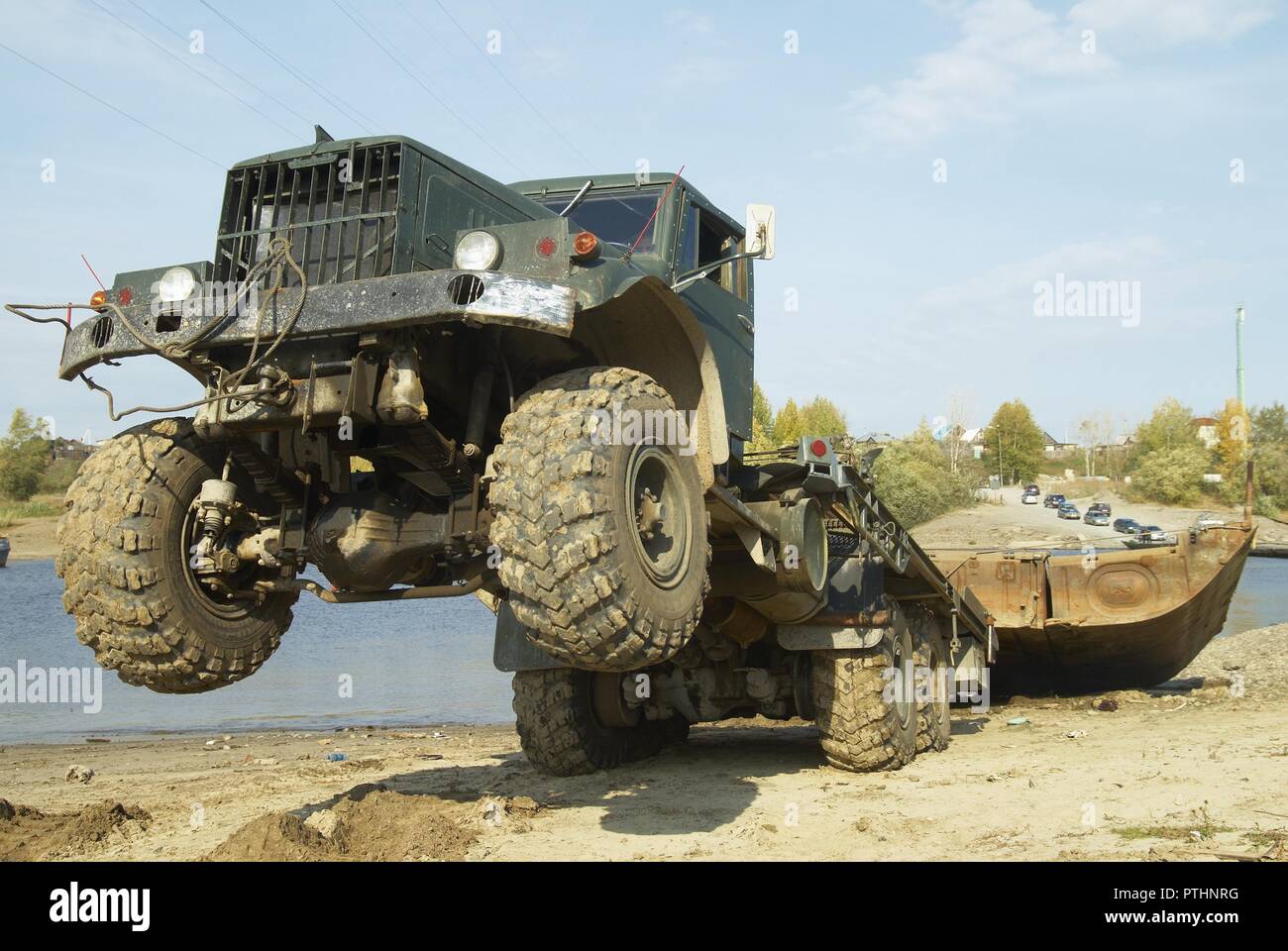 Truck is pulling element of pontoon bridge from river Stock Photo - Alamy