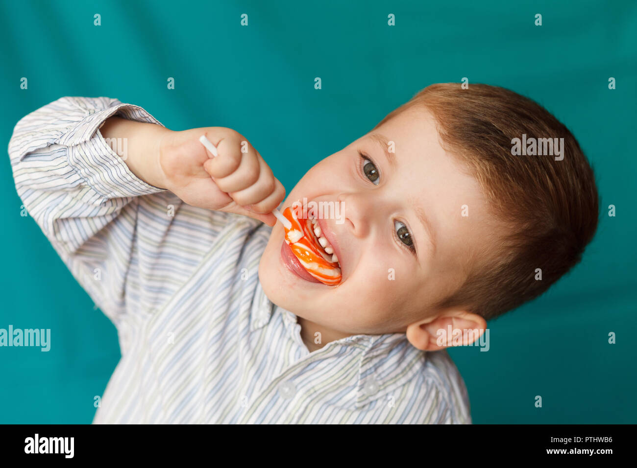 Happy child eating sweets. Child boy eating lollipop isolated Stock ...