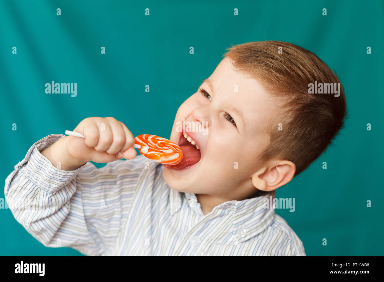 Happy child eating sweets. Child boy eating lollipop isolated Stock ...