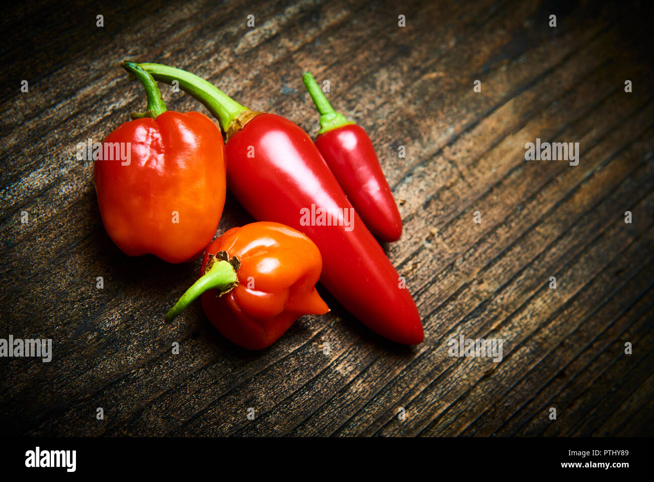 Group of Red fresh chilli on old rustic wood desk. Food background ...