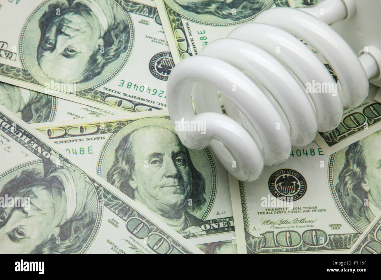 bulb of low consumption on tickets of dollar Stock Photo - Alamy
