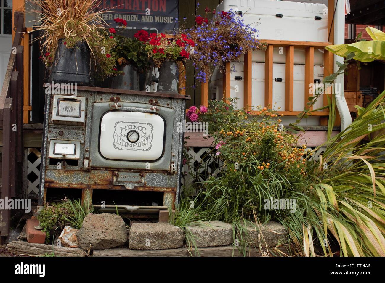 An old rusty cookstove finds new life as a plant stand Stock Photo - Alamy