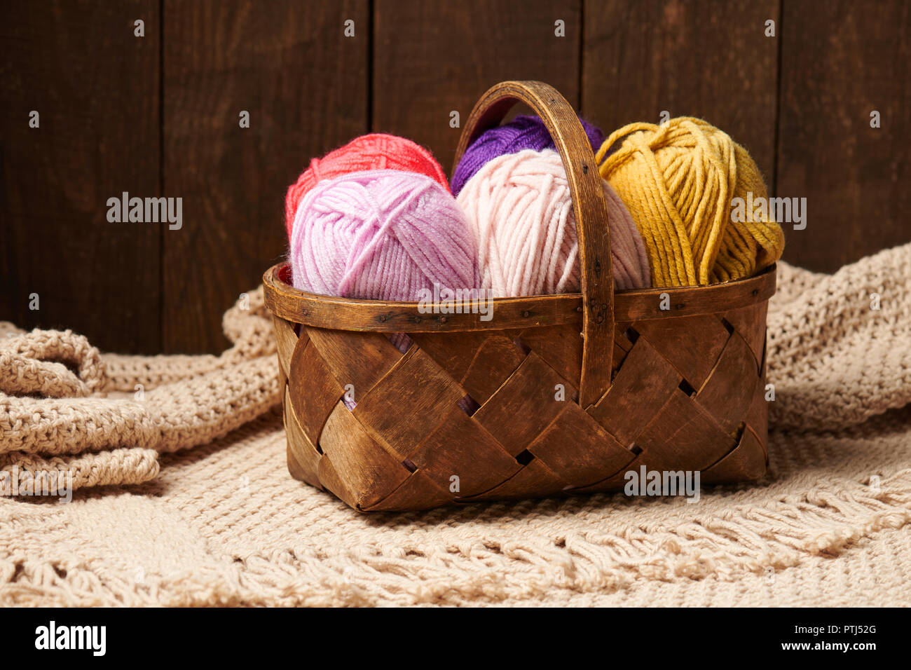 colorful wool threads for knitting in basket, wooden background Stock ...
