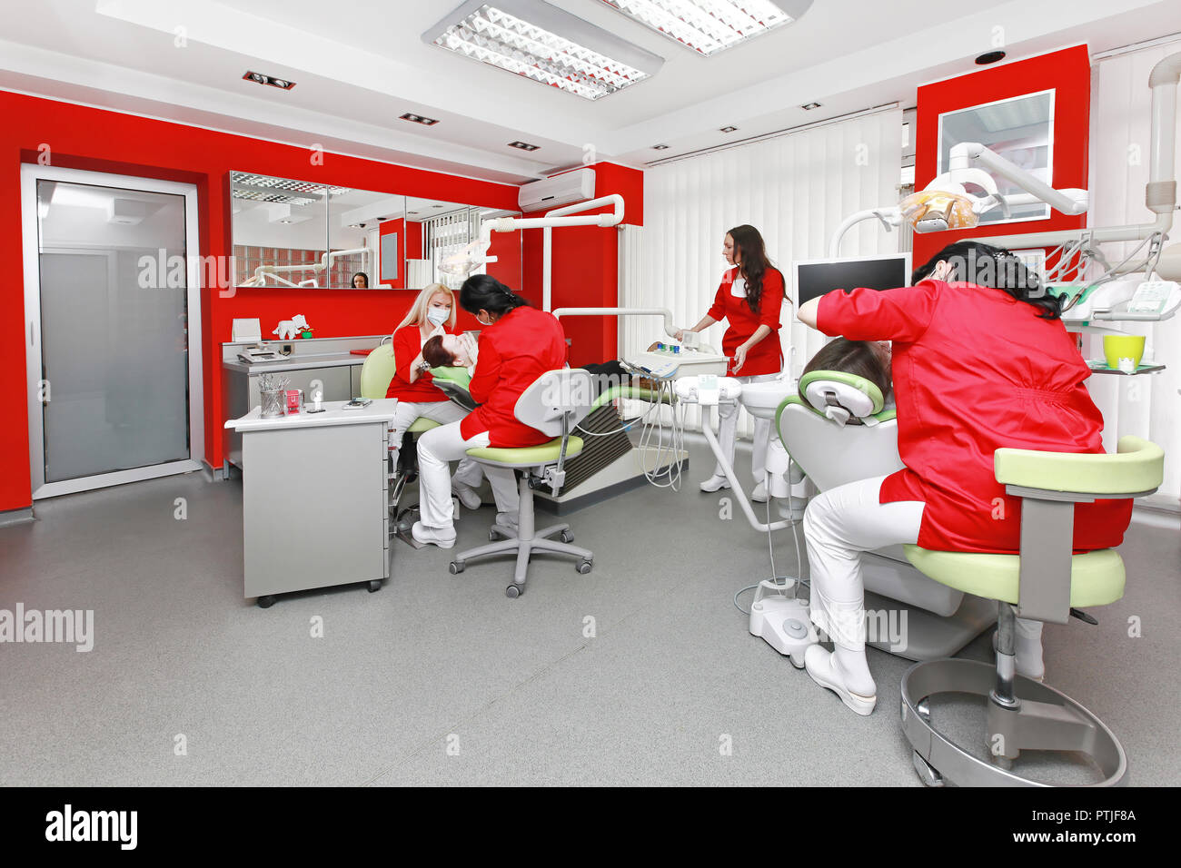 Dentists at work in modern red dental office Stock Photo - Alamy