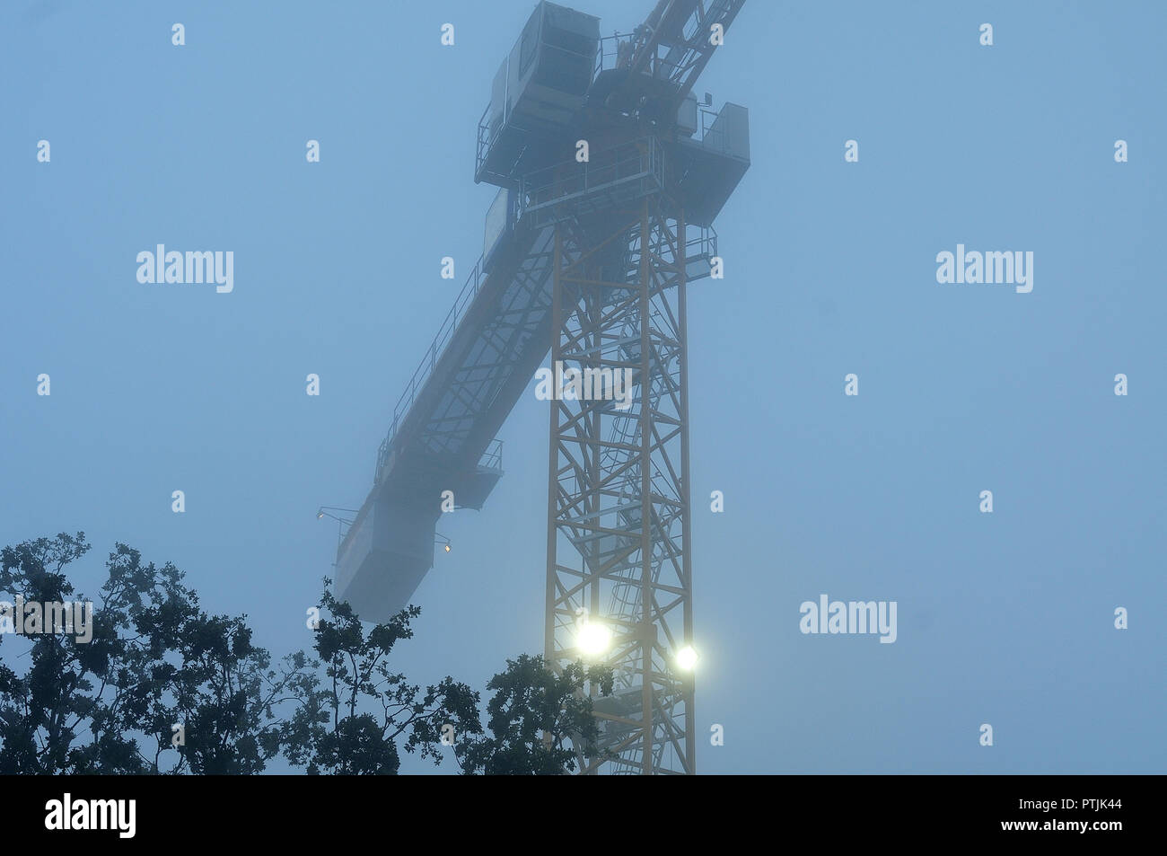 construction crane working in thick fog with bright lights Stock Photo ...