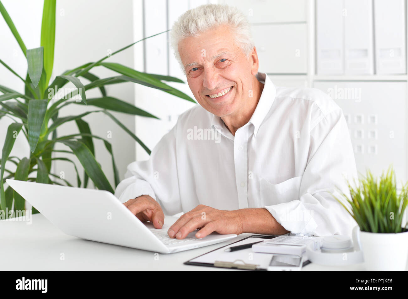 Portrait of a senior businessman working in the office Stock Photo - Alamy