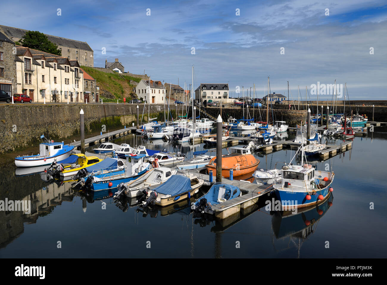 Calm water in the morning at Banff Harbour marina with docked boats and ...