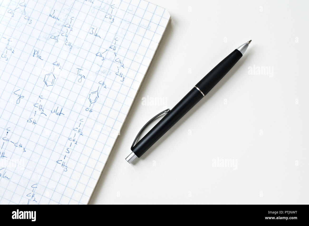 Notebook with chemical formulas and ballpoint pen on white table Stock ...