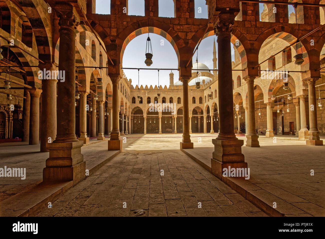 Rows of columns, forming the parallel arcaded sides of the courtyard ...