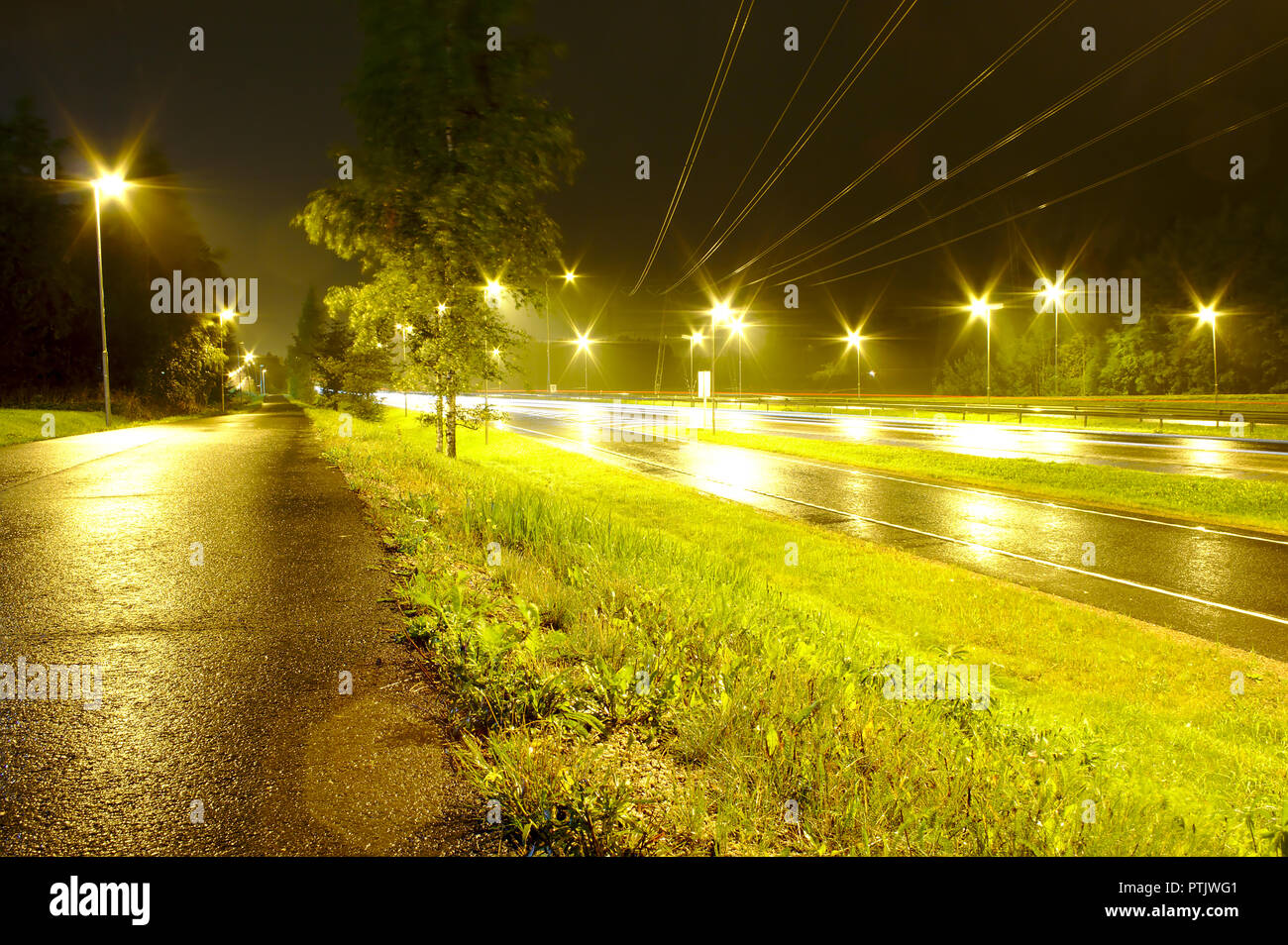 Late night after rain on a motorway. Street light reflecting from wet ...