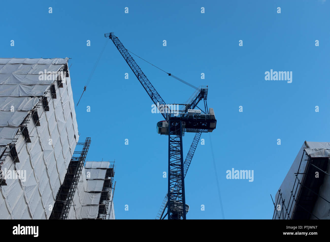 Cranes inside the city constructing a building Stock Photo - Alamy
