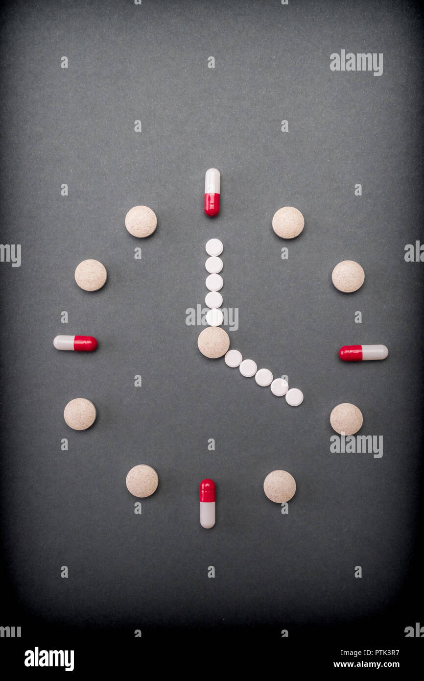 Clock formed by pills tables, conceptual image Stock Photo - Alamy
