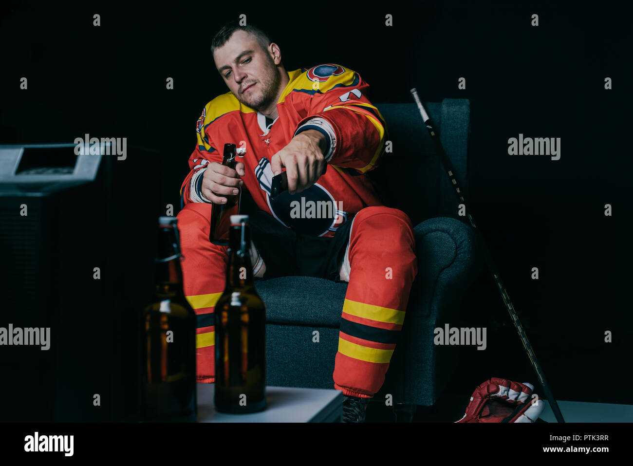 hockey player using remote controller and drinking beer while sitting ...
