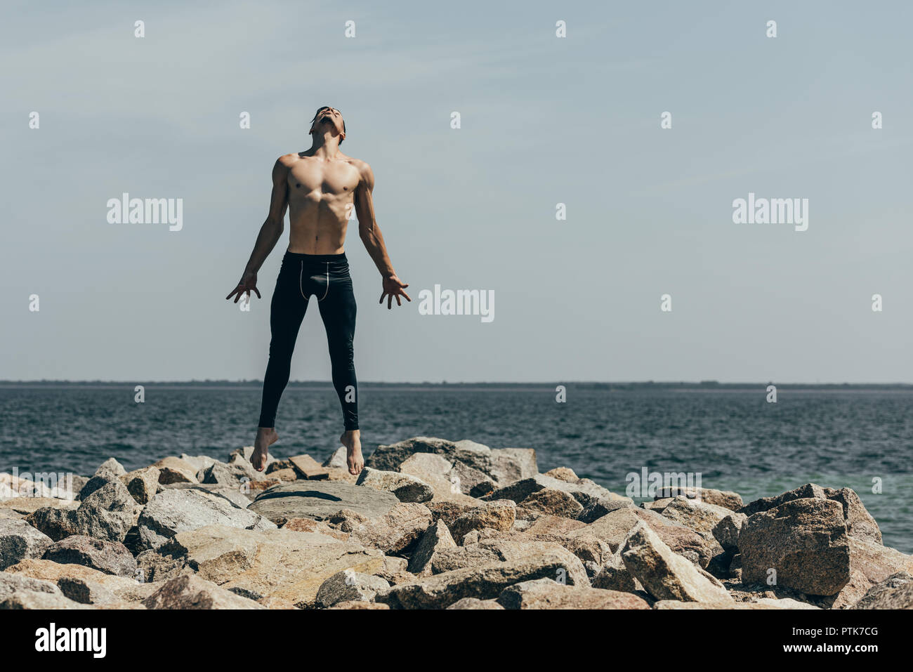 handsome shirtless contemporary dancer jumping on rocky coast Stock ...