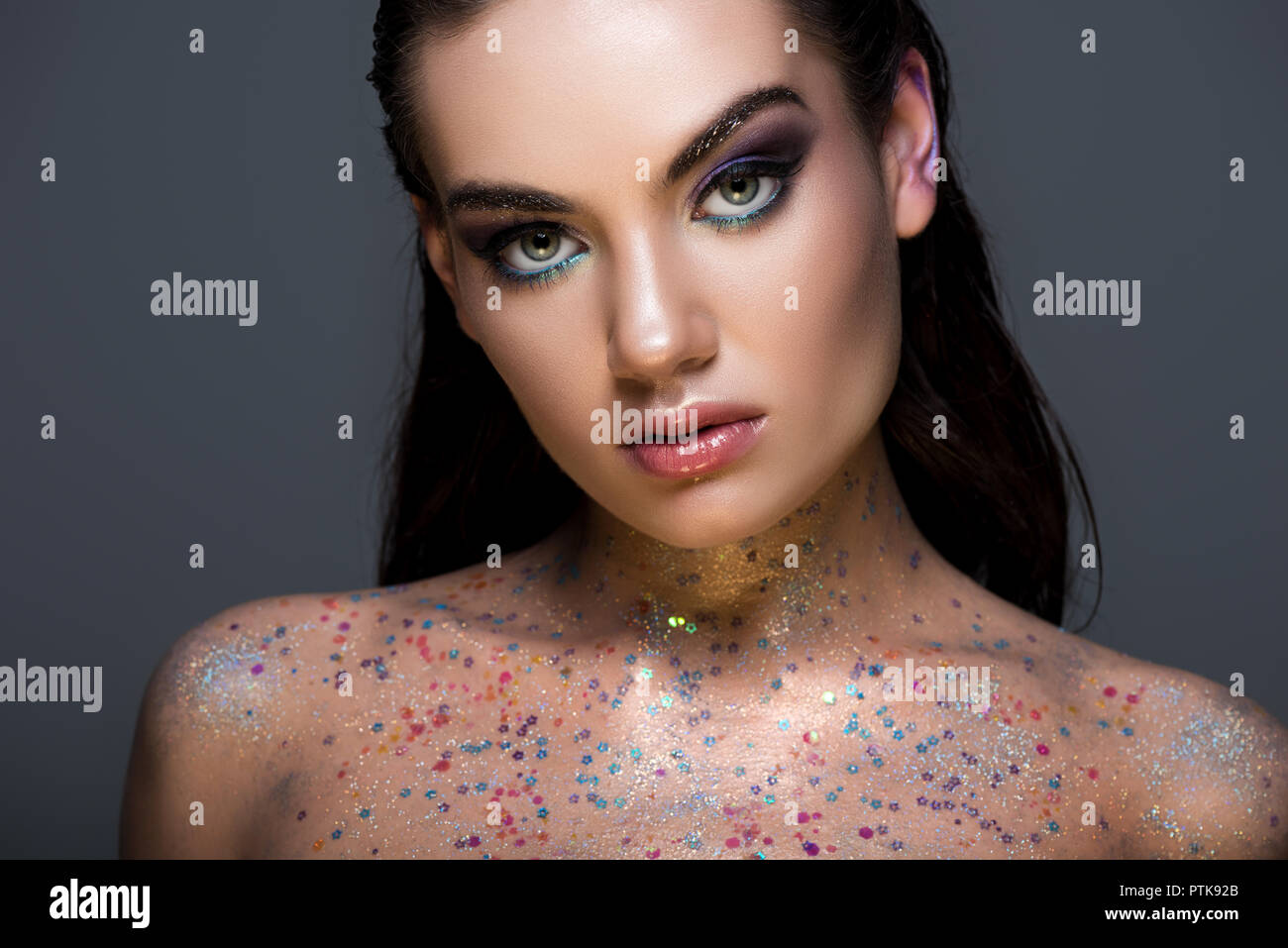 beautiful glamorous young model posing with glitter on body and looking ...