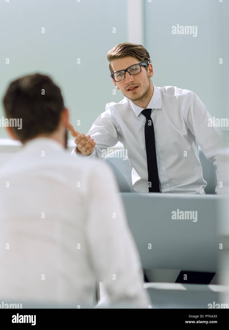 two business people talking sitting in the lobby of the office Stock ...