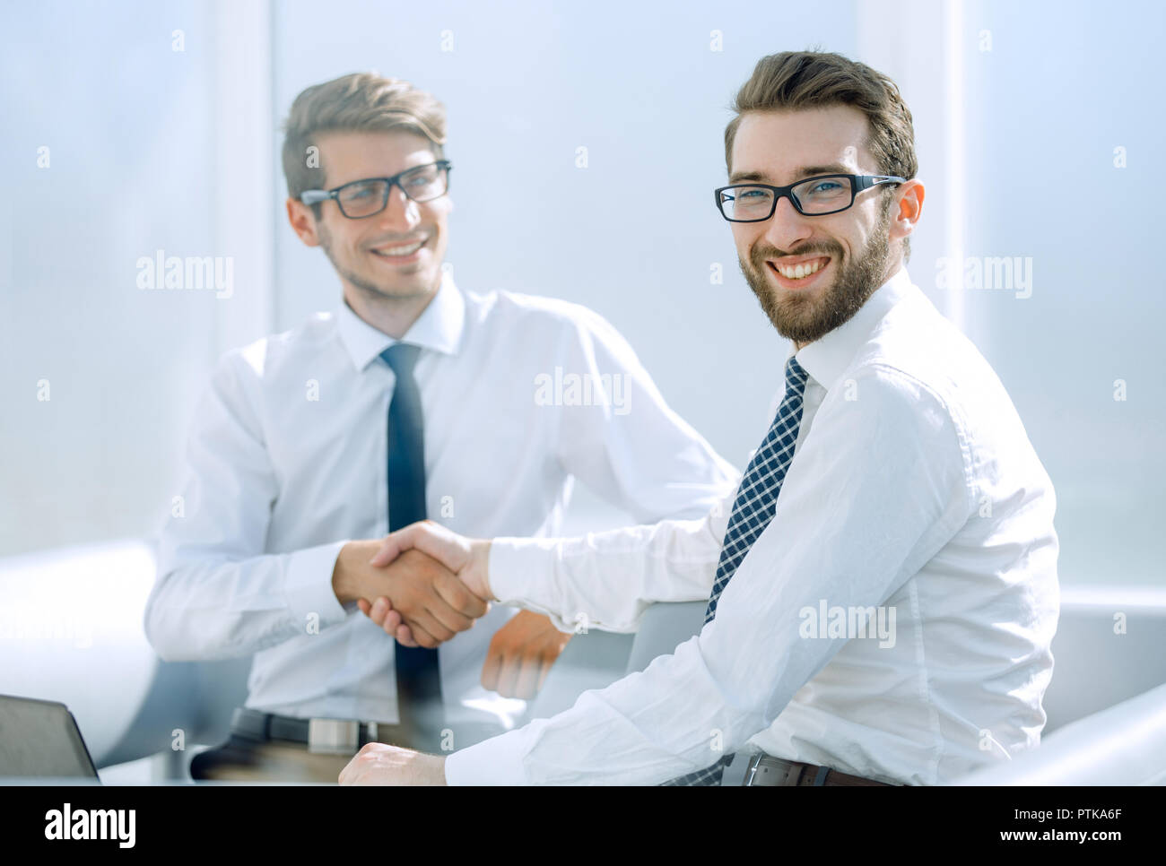 successful employees shaking hands sitting at the Desk Stock Photo - Alamy