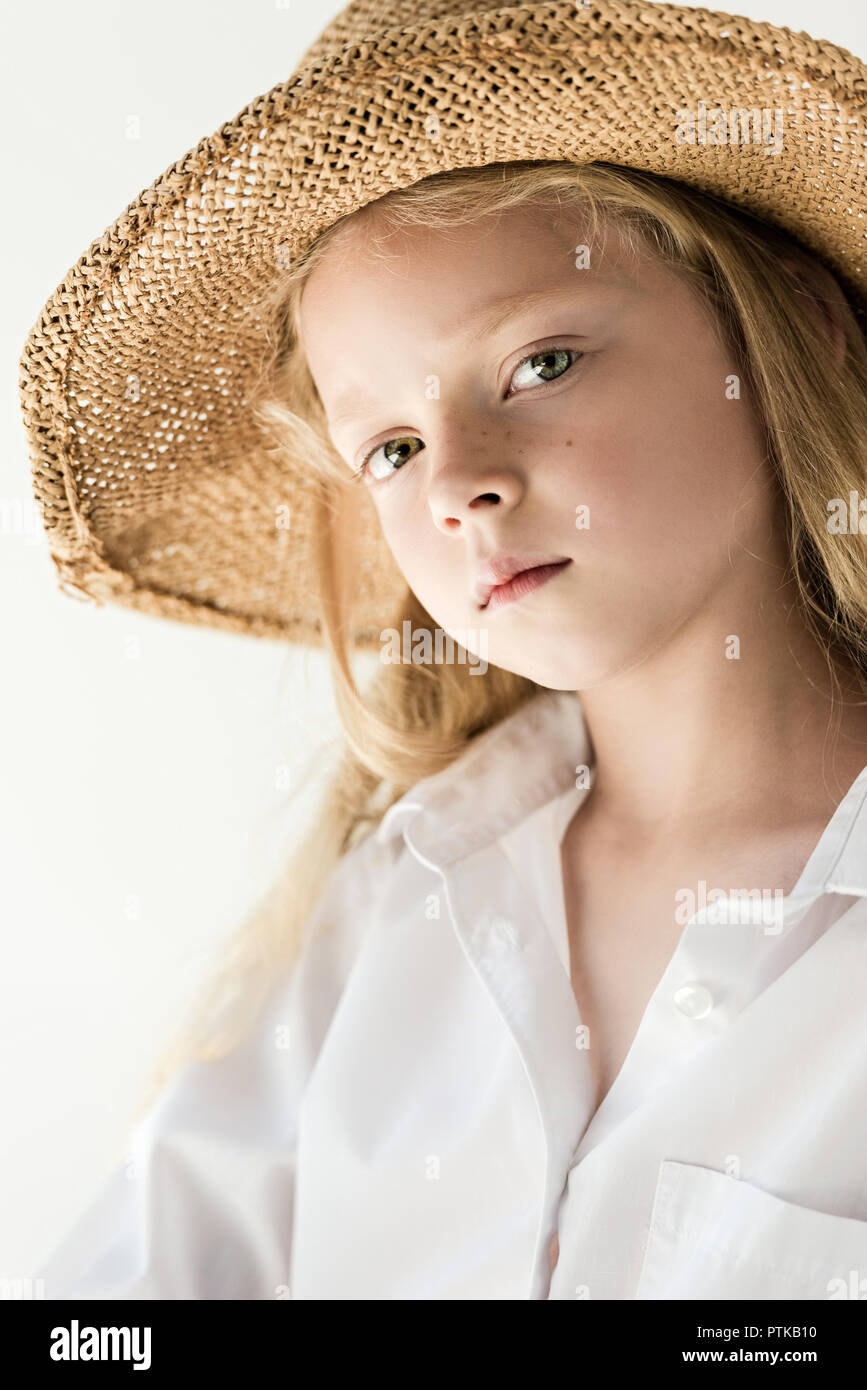 portrait of beautiful little kid in wicker hat looking at camera on ...