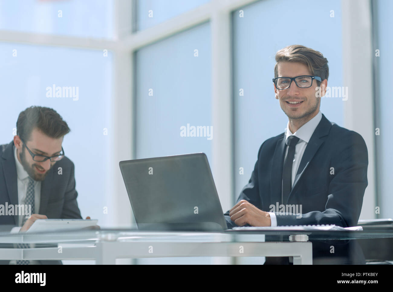 two business people talking sitting at a Desk Stock Photo - Alamy