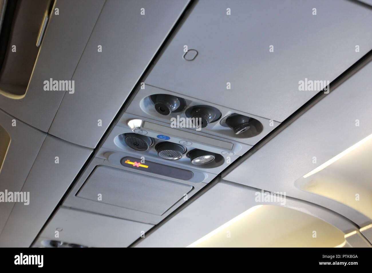 closeup of air grille diffuser and lamp on ceiling in the airplane ...