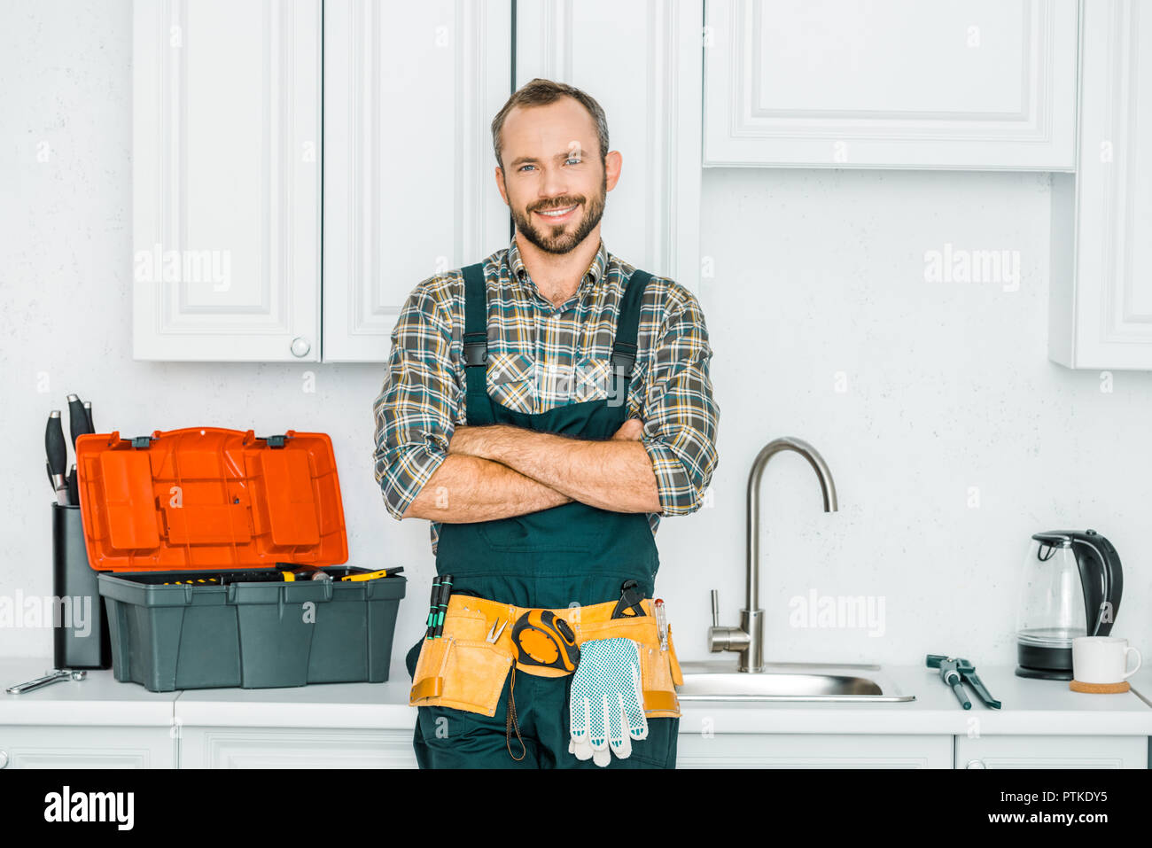 Handsome smiling plumber at the kitchen hi-res stock photography and ...