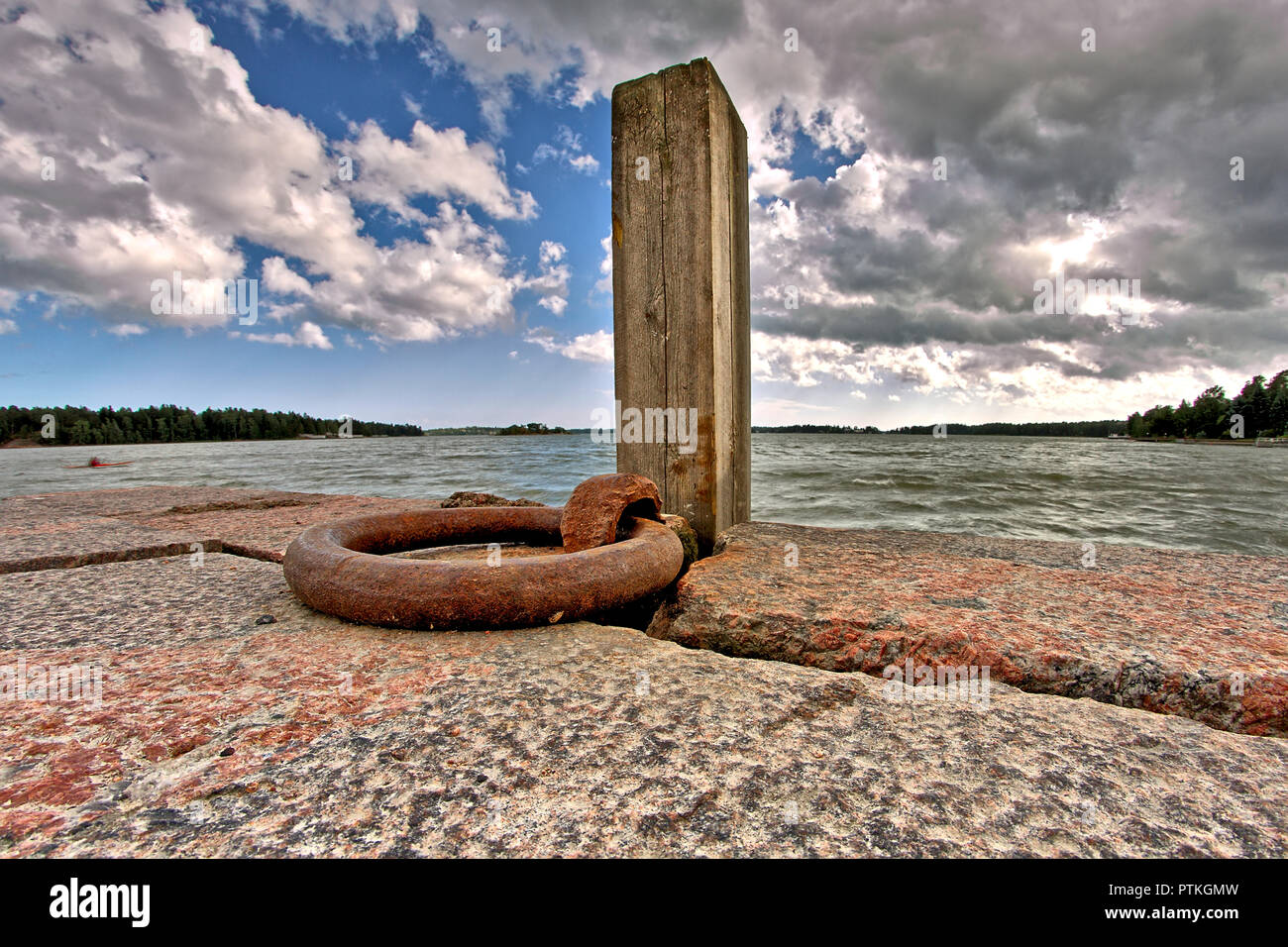 Stone boat dock by the sea with wooden pole Stock Photo - Alamy