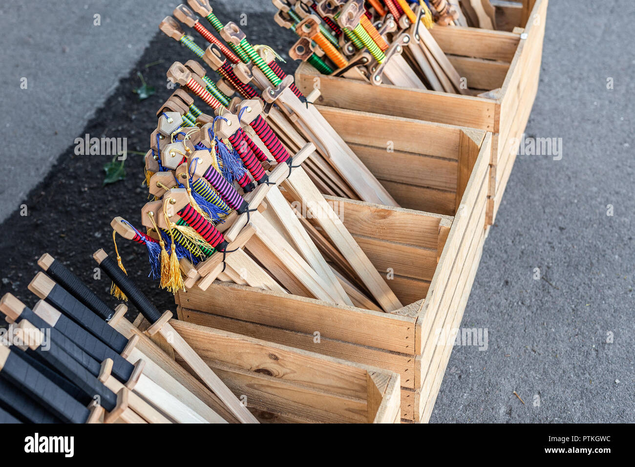 Heap of many wooden toy medieval swords in boxes at souvenir shop ...