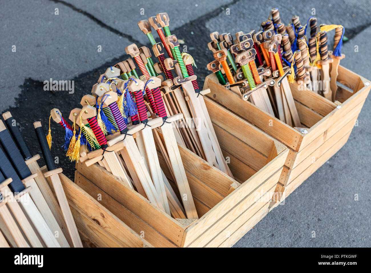 Heap of many wooden toy medieval swords in boxes at souvenir shop ...