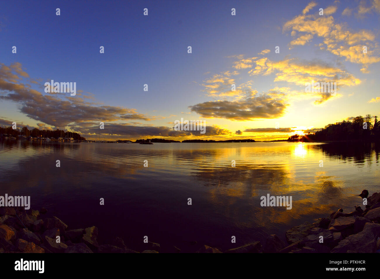 Stunning mid summer sunset by the water. Sunset reflecting from the surface Stock Photo - Alamy