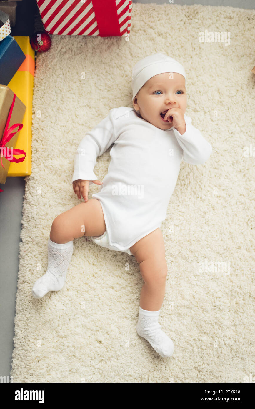 adorable little baby lying on floor with gift boxes Stock Photo - Alamy