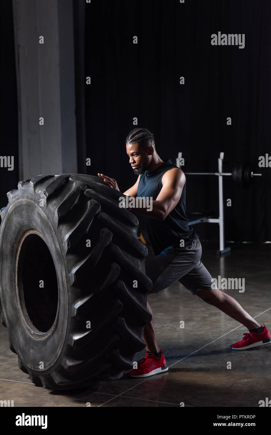 side view of muscular young african american sportsman exercising with ...
