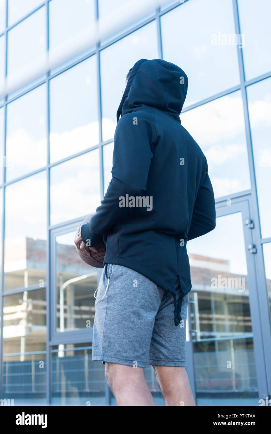 back view of sportive man holding basketball ball on street Stock Photo ...