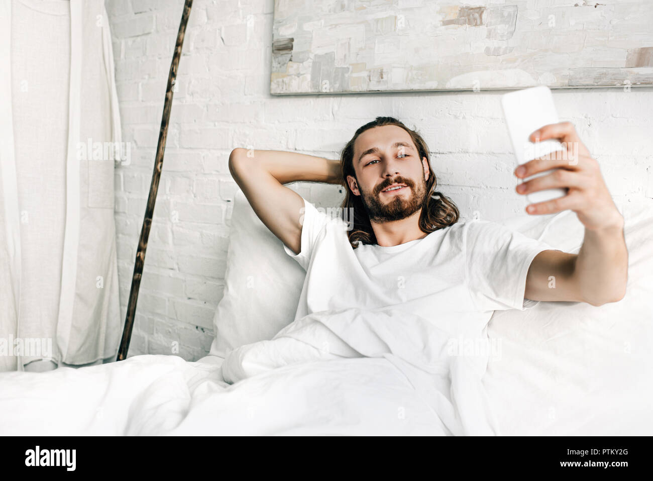 smiling Jesus taking selfie in bed during morning time at home Stock ...