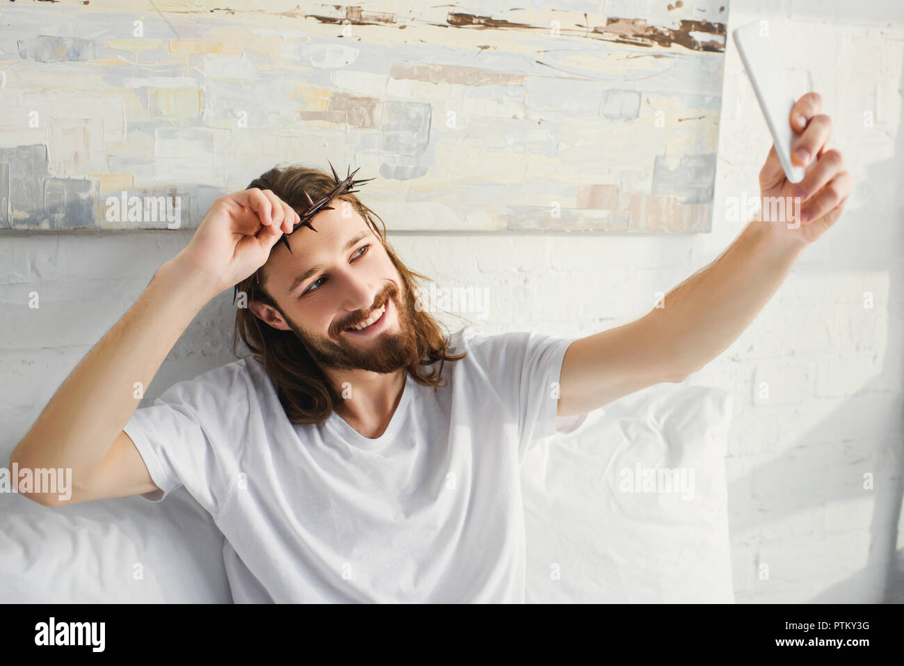 happy Jesus in crown of thorns taking selfie in bed during morning time ...
