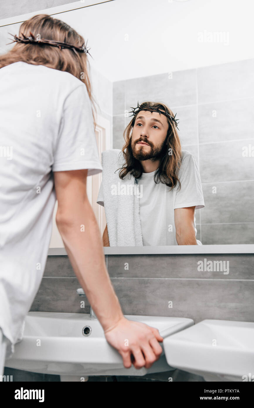 rear view of Jesus with towel over shoulder looking at own reflection ...