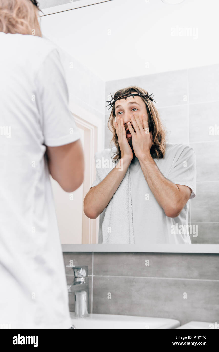 rear view of Jesus with towel over shoulder looking at own reflection ...